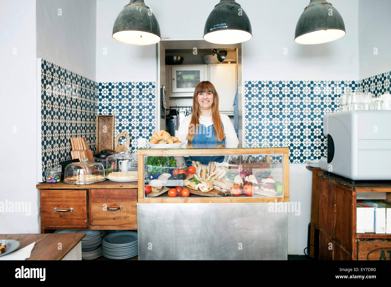 Cafe owner behind counter Stock Photo - Alamy