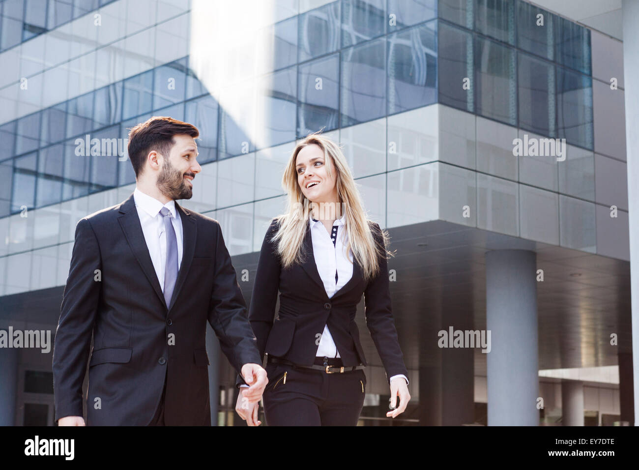 Business partners walking against office building Stock Photo - Alamy