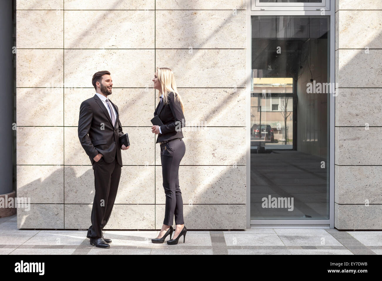 Business partners talking by office building Stock Photo - Alamy