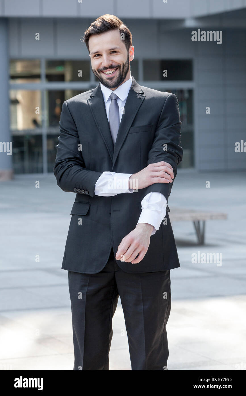 Portrait of business man adjusting cuffs Stock Photo - Alamy