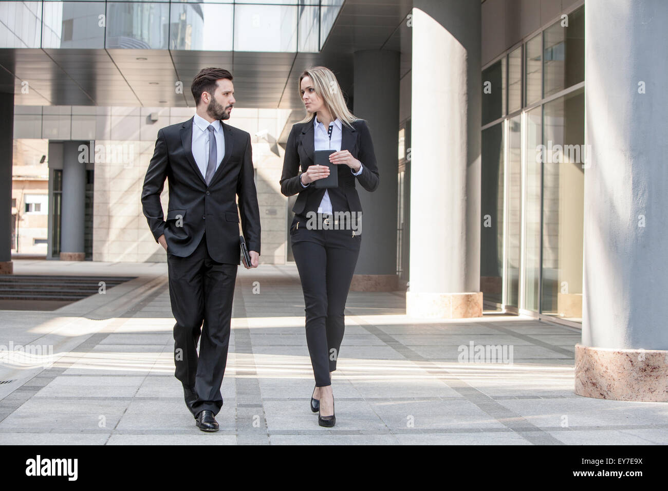Business partners walking by office building Stock Photo - Alamy
