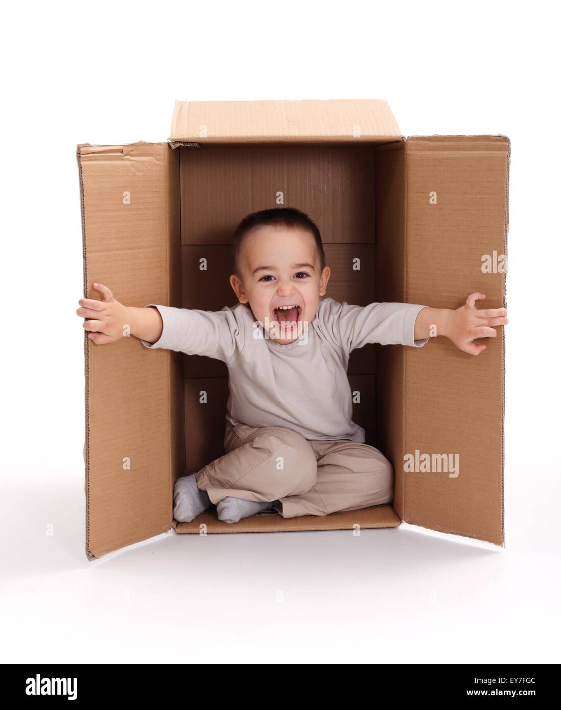 Happy little boy sitting inside cardboard box, opening Stock Photo - Alamy
