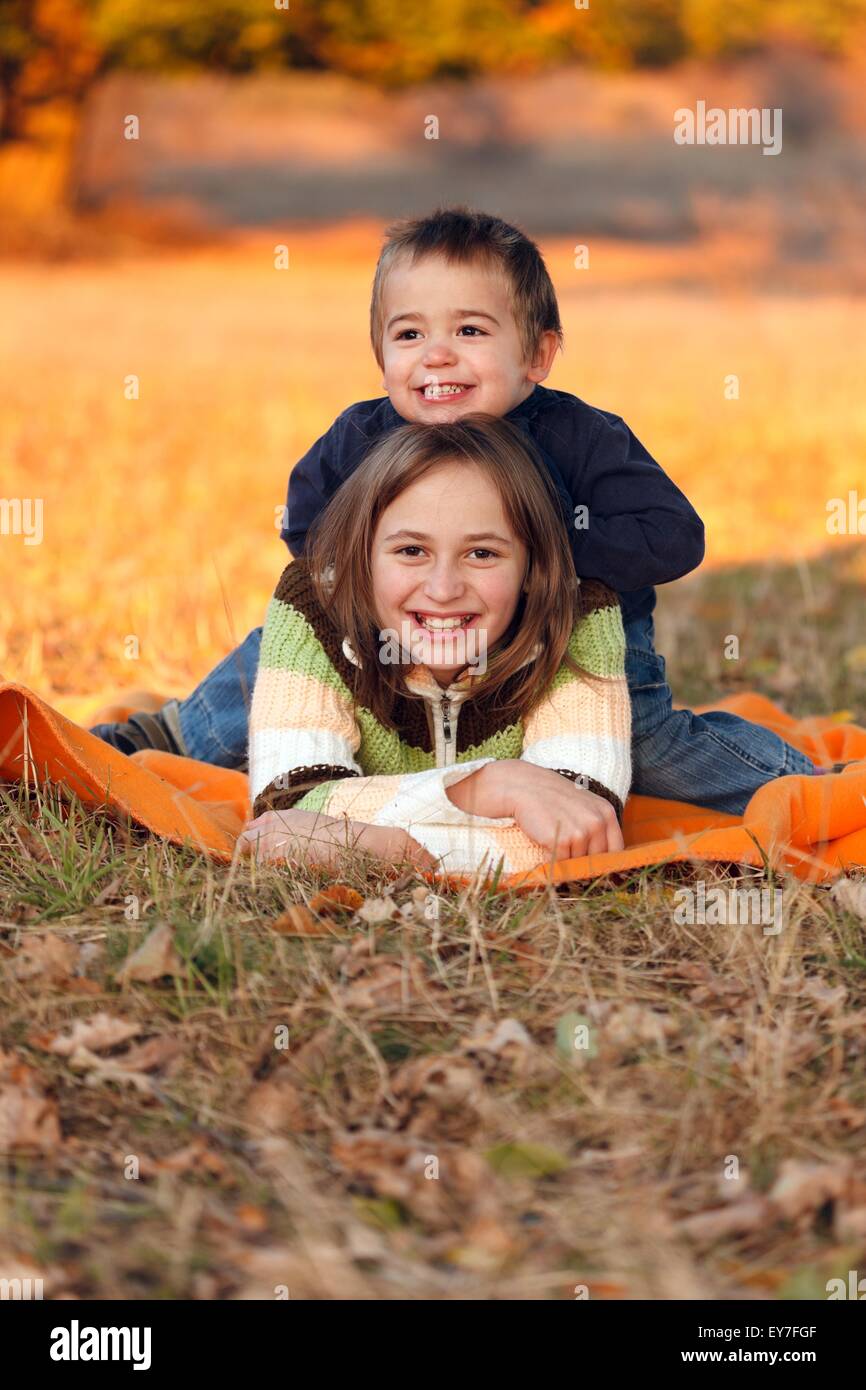 Happy kids playing outdoors in autumn Stock Photo - Alamy
