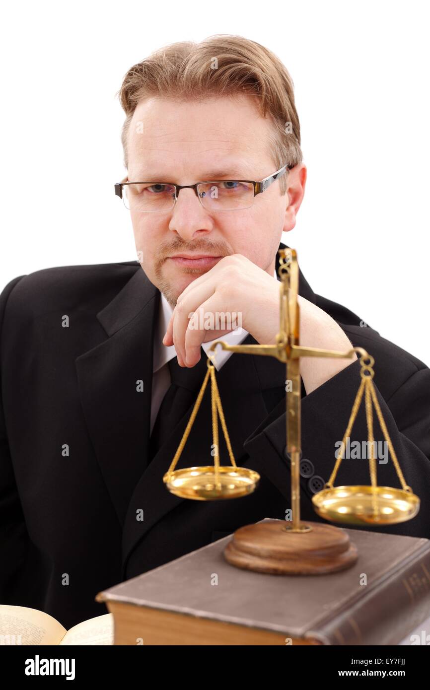 Serious attorney thinking, small golden scale on books in front of him ...