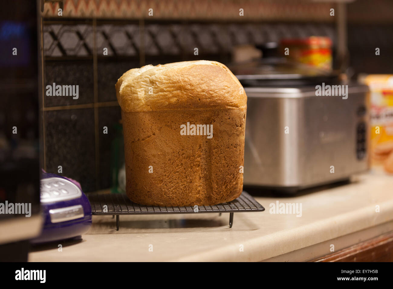 Freshly baked loaf from a bread machine. Cooling on a wire rack on a ...