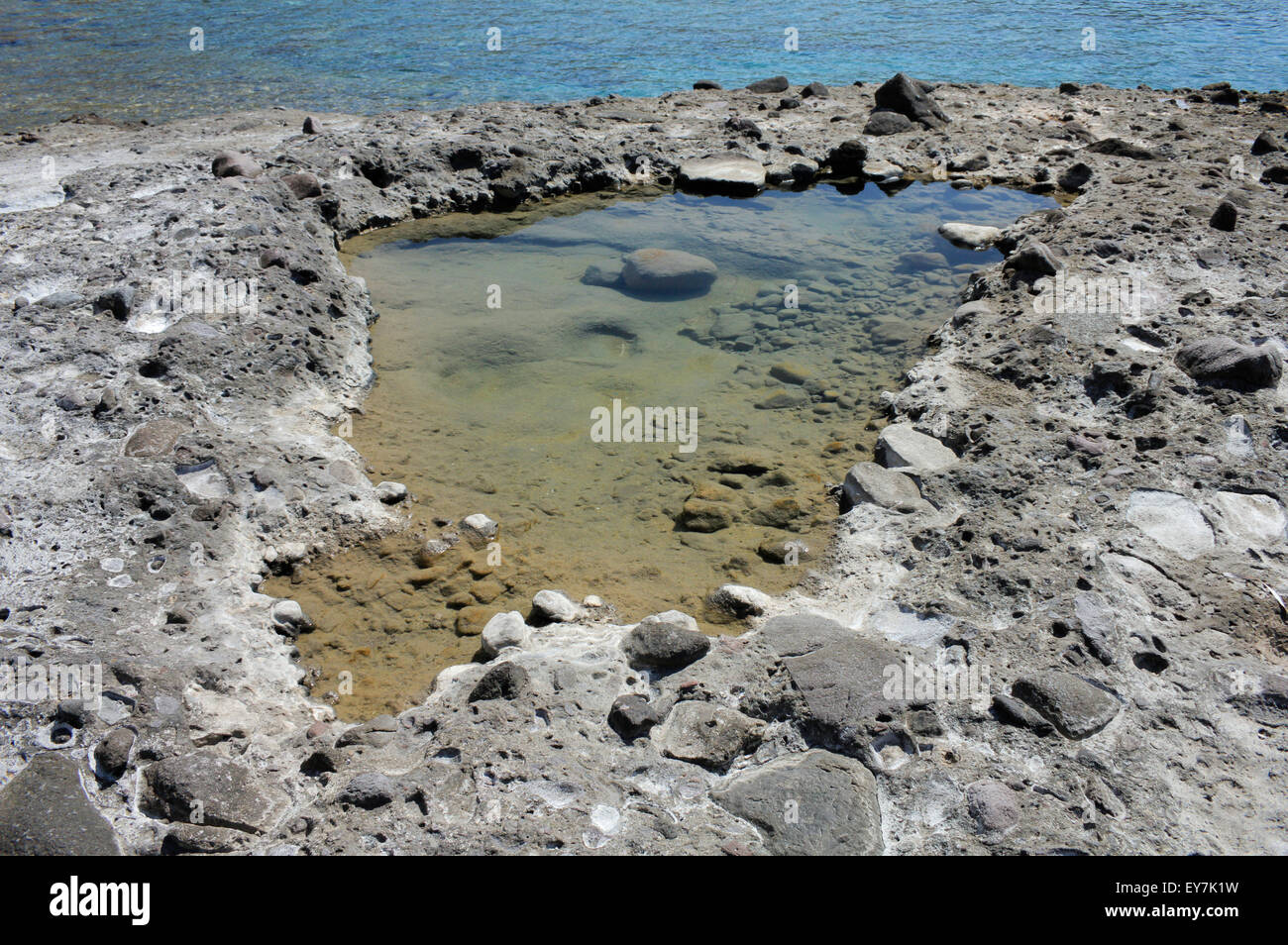 Volcanic eroded rock formations and stagnant sea waters. Small Mourouli ...