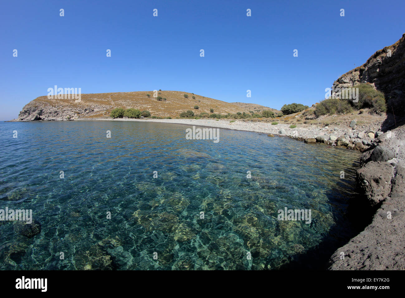 Limpid sea waters and peebly seaside of Big Mourouli beach. Agios ...