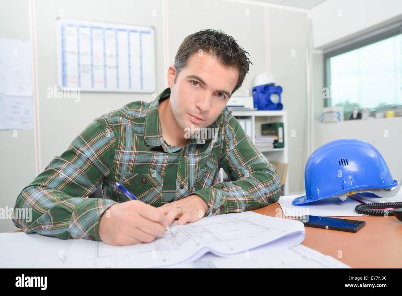 Construction worker at desk Stock Photo - Alamy