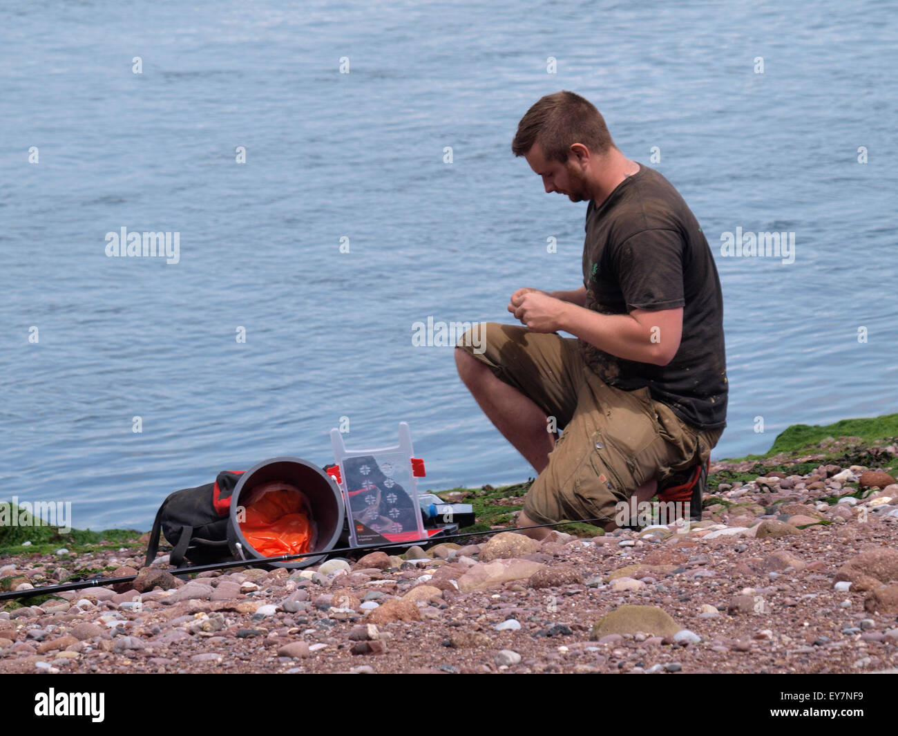 Fisherman preparing his line on the estuary of the River Teign at ...
