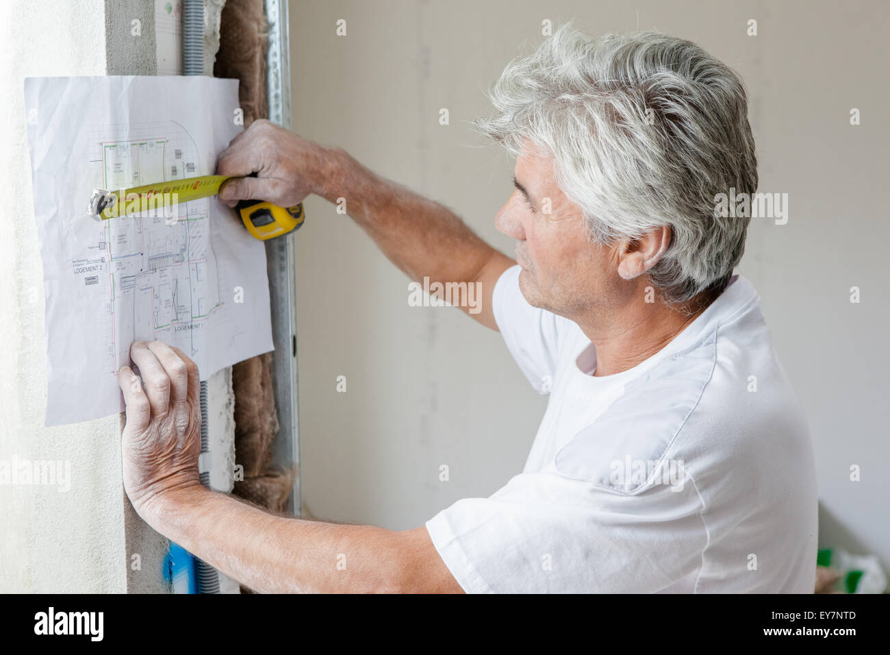 Mason measuring plans Stock Photo - Alamy