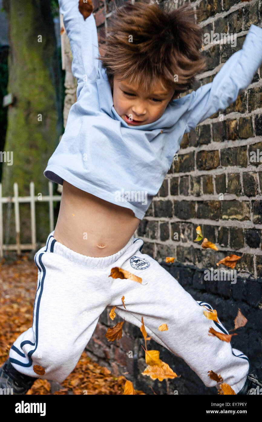 Caucasian child, boy enjoying himself in a road by wall, by taking ...