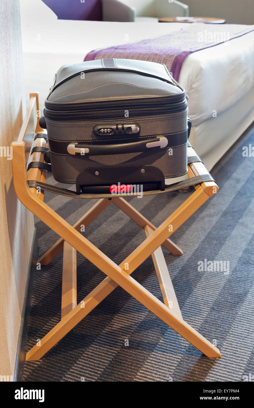 Hotel room with a suitcase on the luggage place and the bed Stock Photo ...