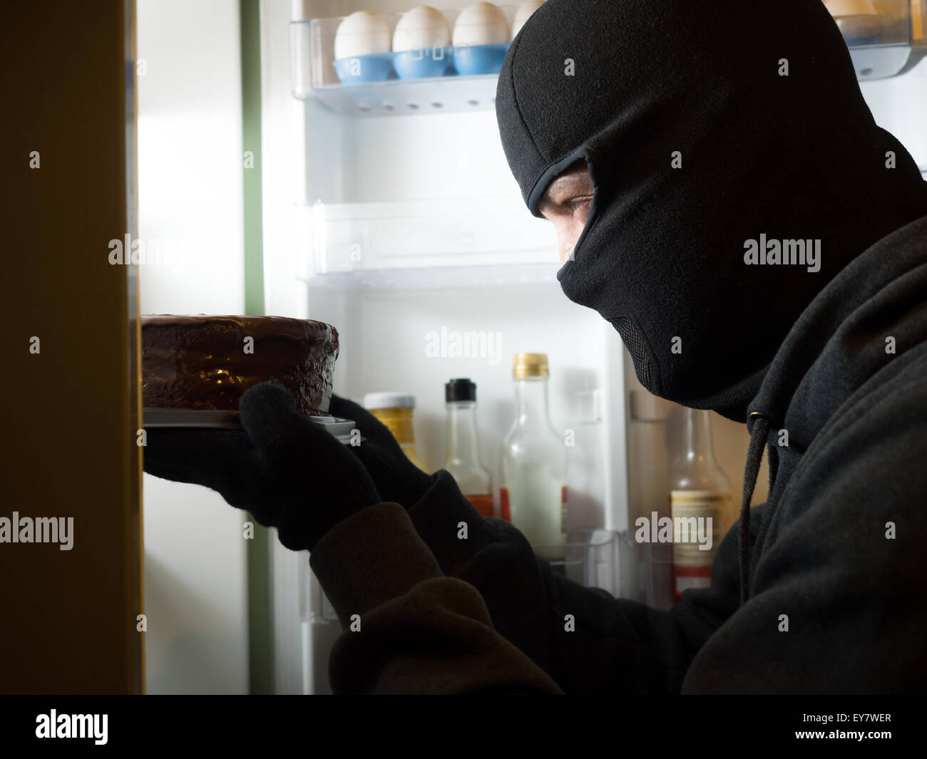 Thief. Man in black mask with a cake Stock Photo - Alamy