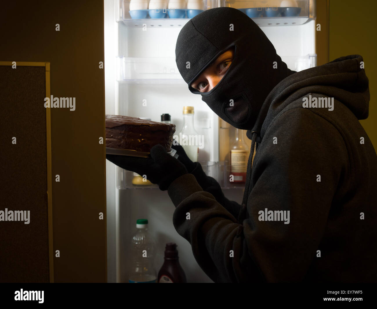 Thief. Man in black mask with a cake Stock Photo - Alamy