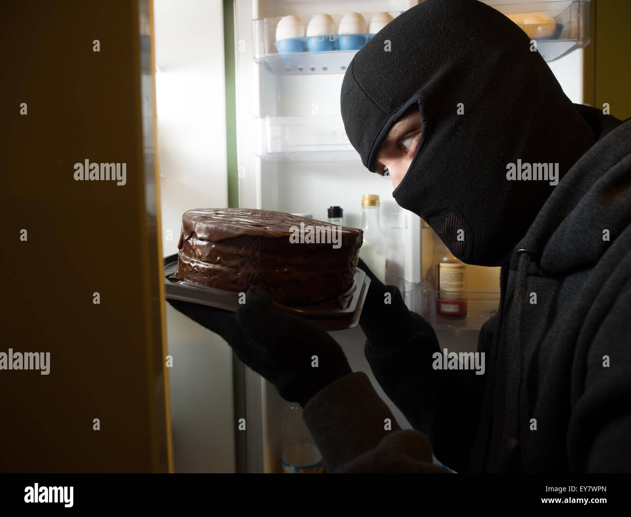 Thief. Man in black mask with a cake Stock Photo - Alamy