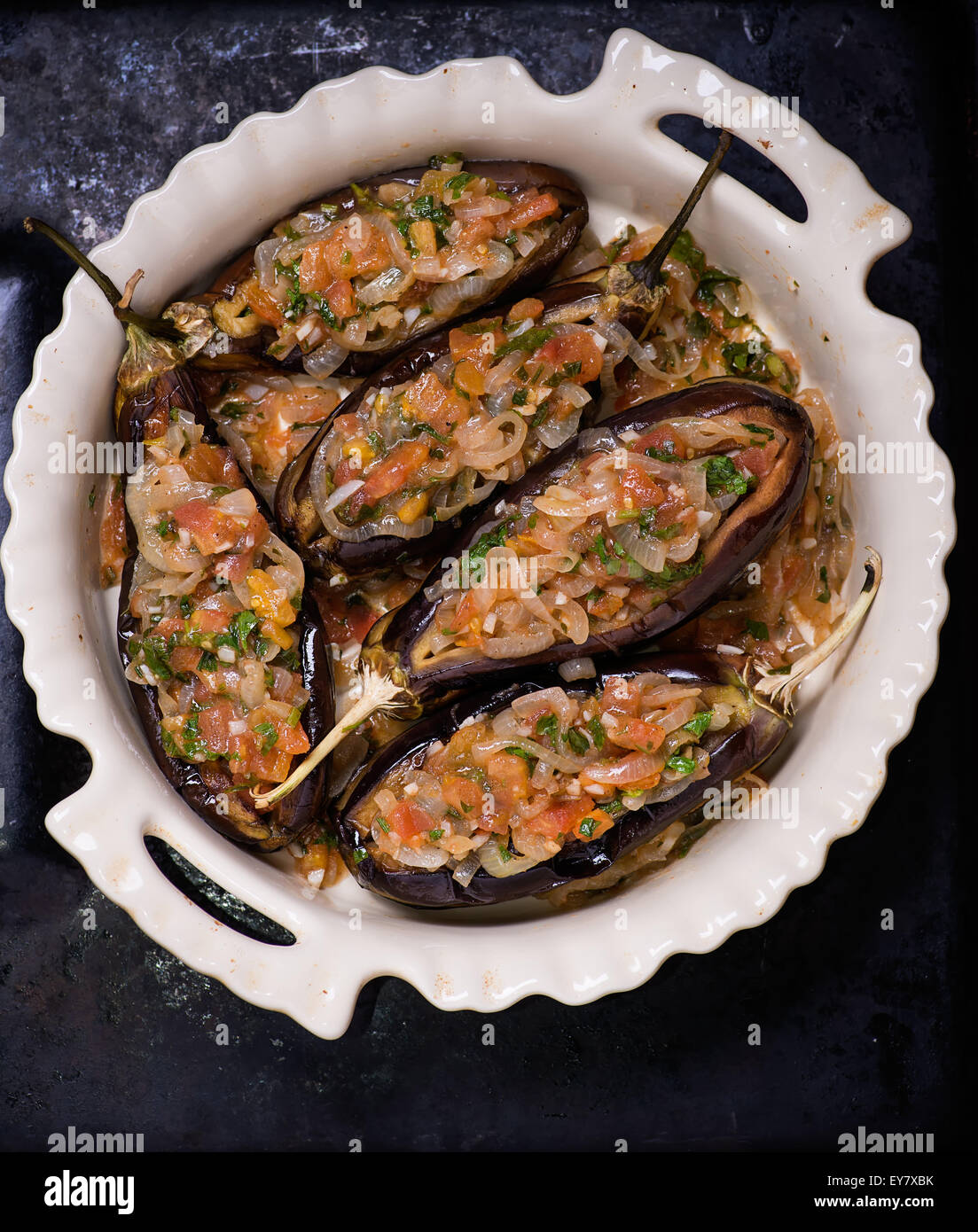 Imam Bayildi. Eggplants stuffed with vegetables in a baking tray ...