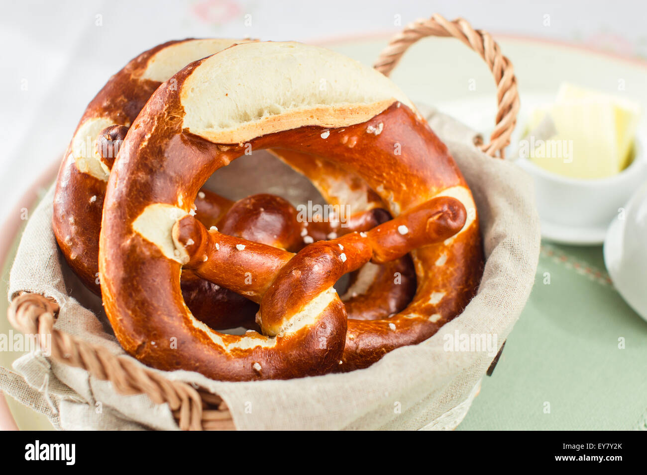 Delicious german pretzels with butter on sunlighted table. For ...