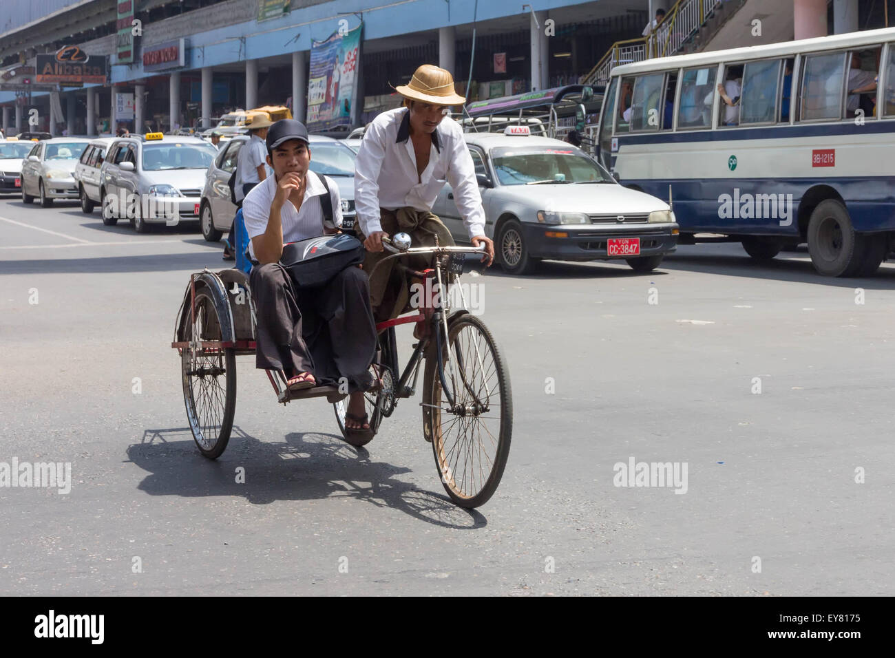 Yangon, Myanmar-May 7th 2014: A rickshaw carries a passenger to his ...