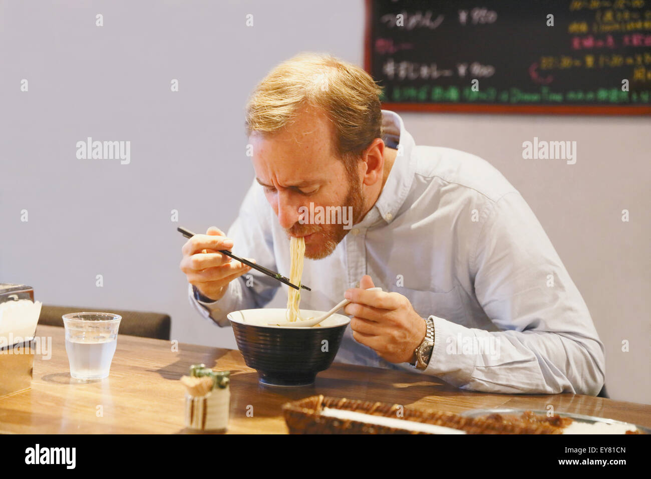 Caucasian man with beard eating ramen noodles Stock Photo - Alamy