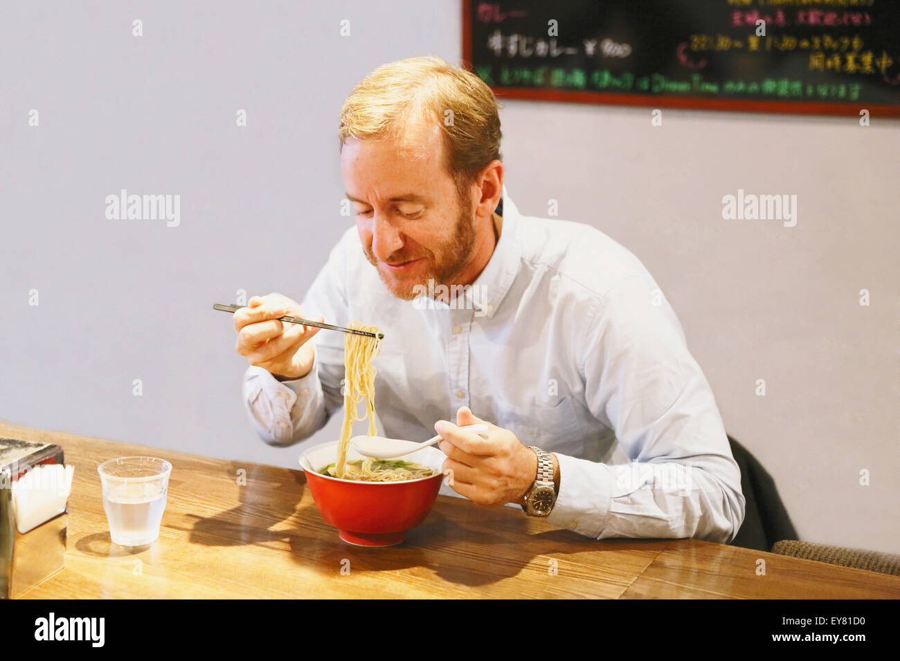 Caucasian man with beard eating ramen noodles Stock Photo - Alamy