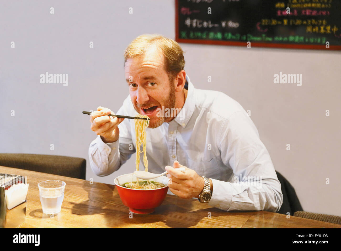 Caucasian man with beard eating ramen noodles Stock Photo - Alamy