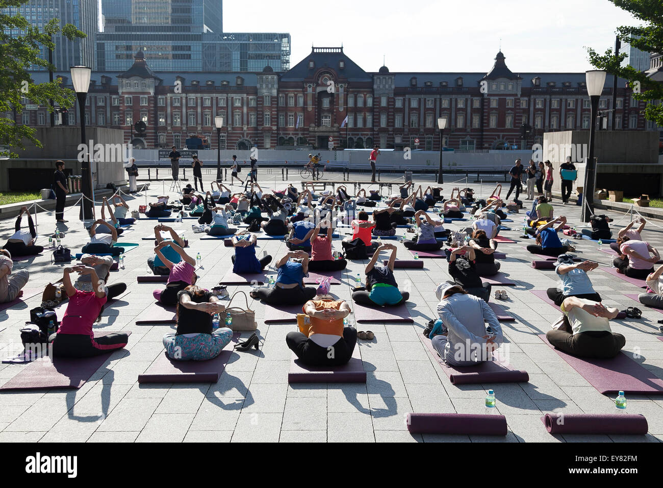 Office workers practice yoga early morning in front of Tokyo Station ...