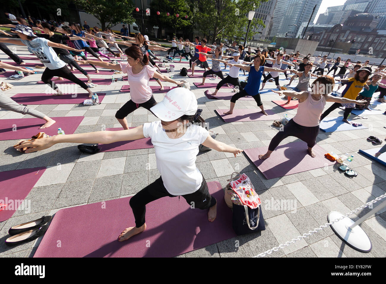 Office workers practice yoga early morning in front of Tokyo Station ...