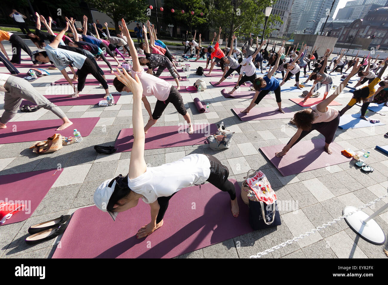 Office workers practice yoga early morning in front of Tokyo Station ...