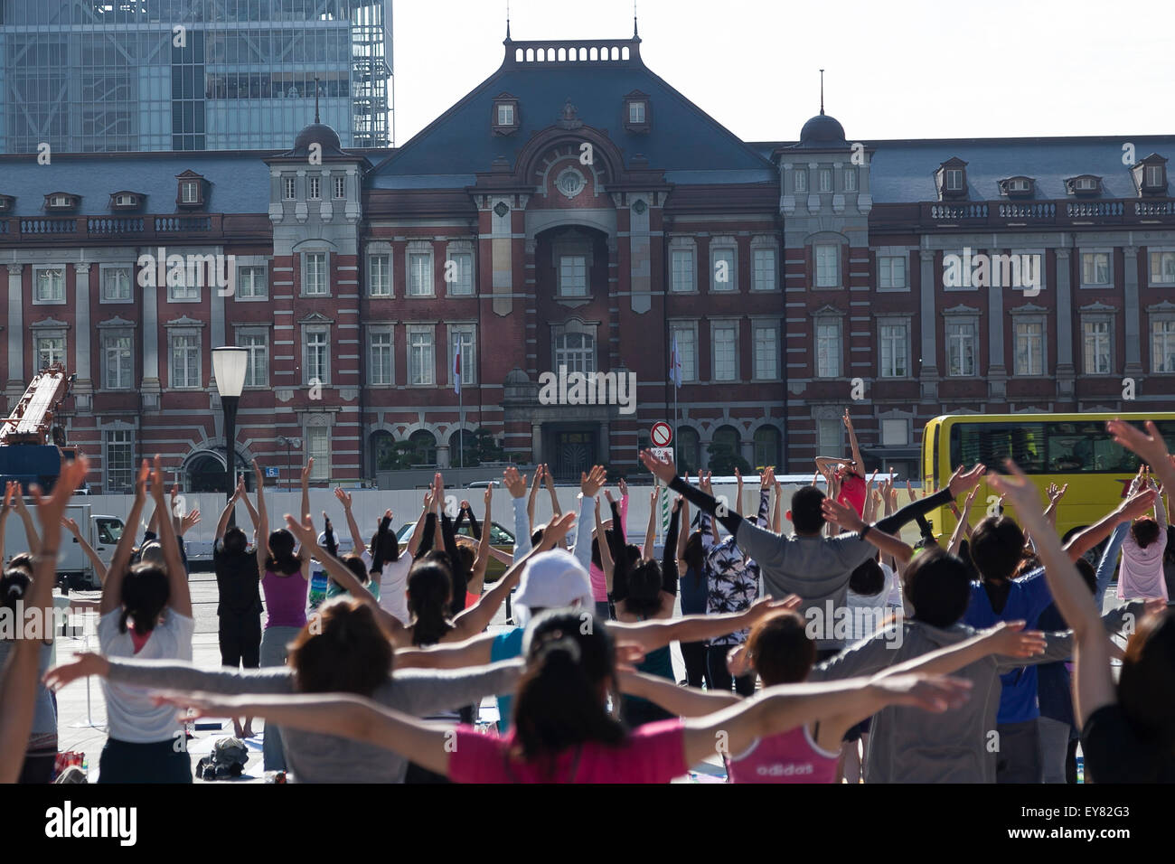 Office workers practice yoga early morning in front of Tokyo Station ...