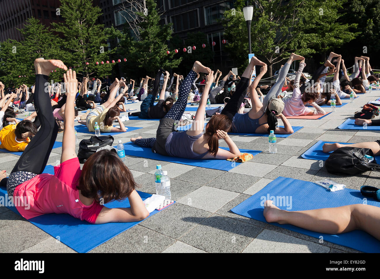 Office workers practice yoga early morning in front of Tokyo Station ...