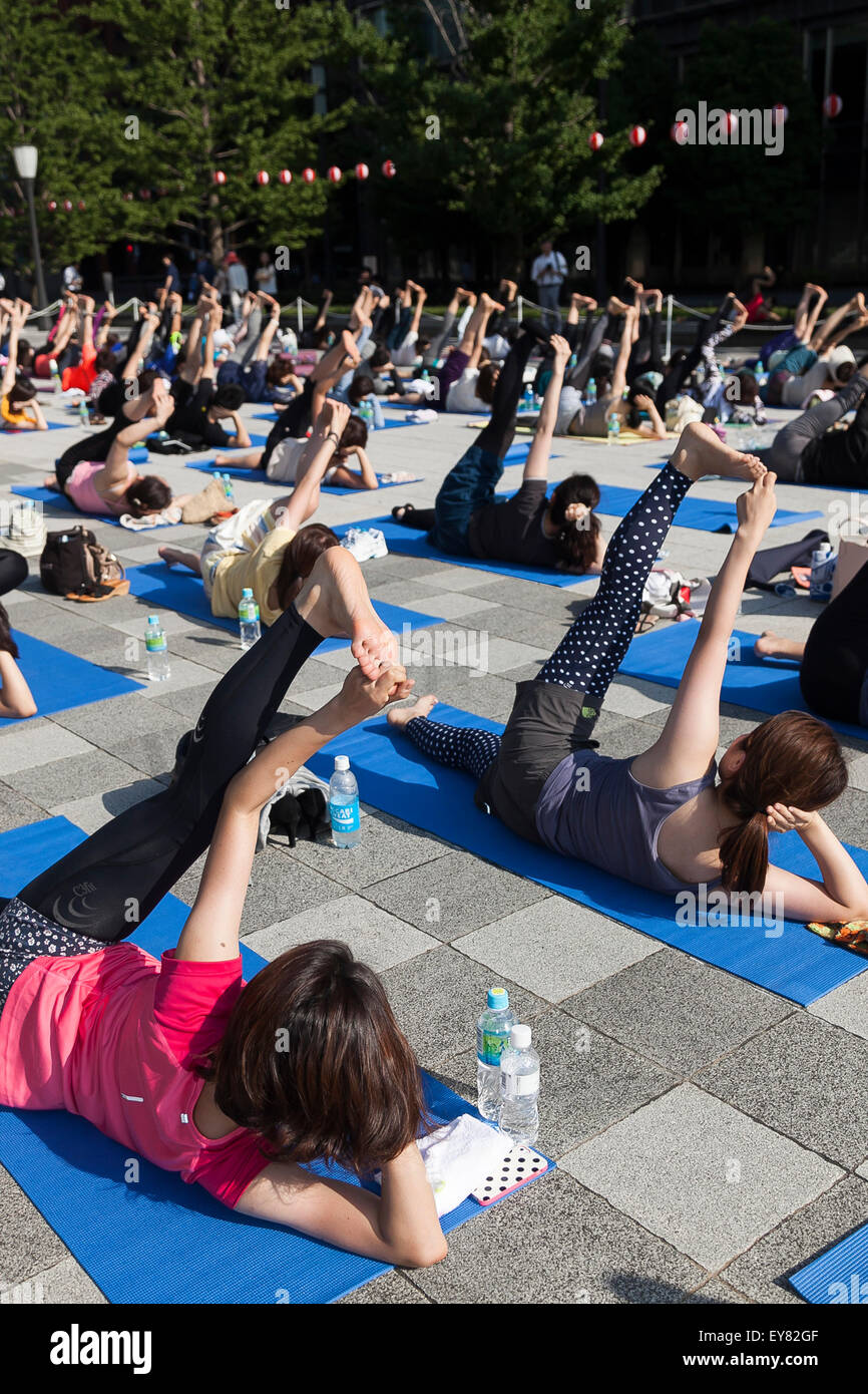 Office workers practice yoga early morning in front of Tokyo Station ...