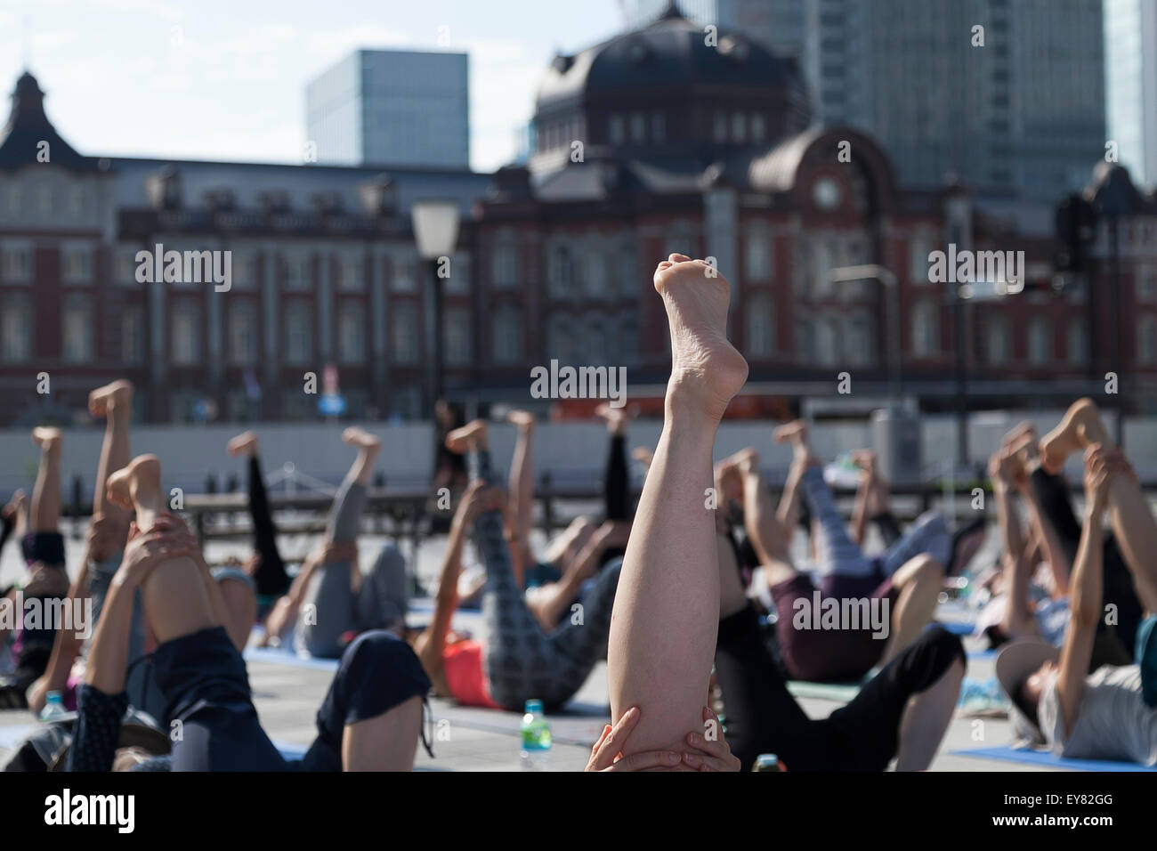 Office workers practice yoga early morning in front of Tokyo Station ...