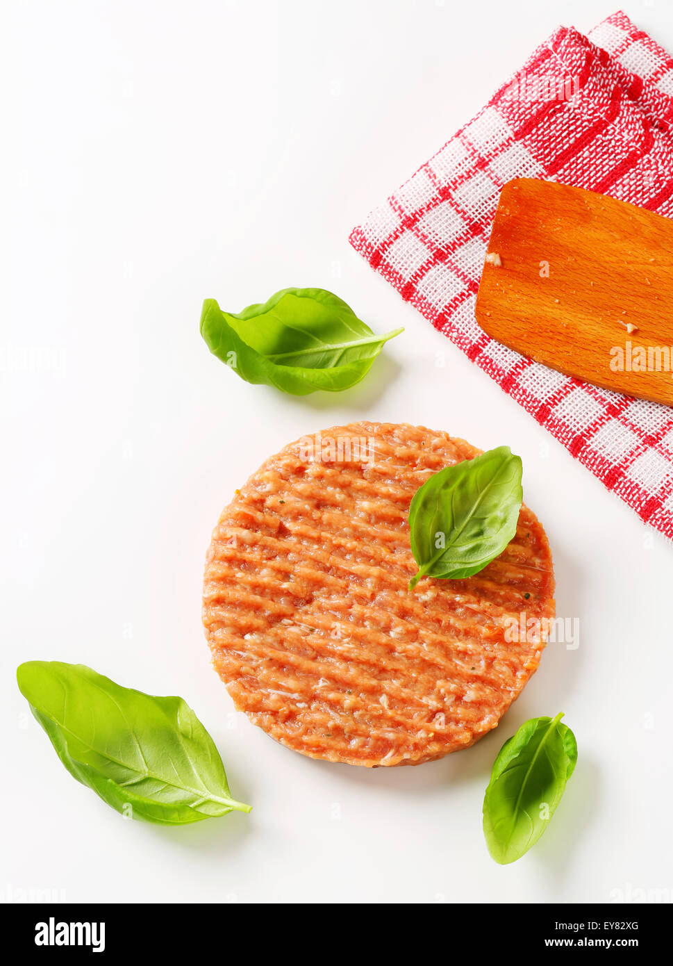 Raw burger patty with fresh basil leaves Stock Photo - Alamy