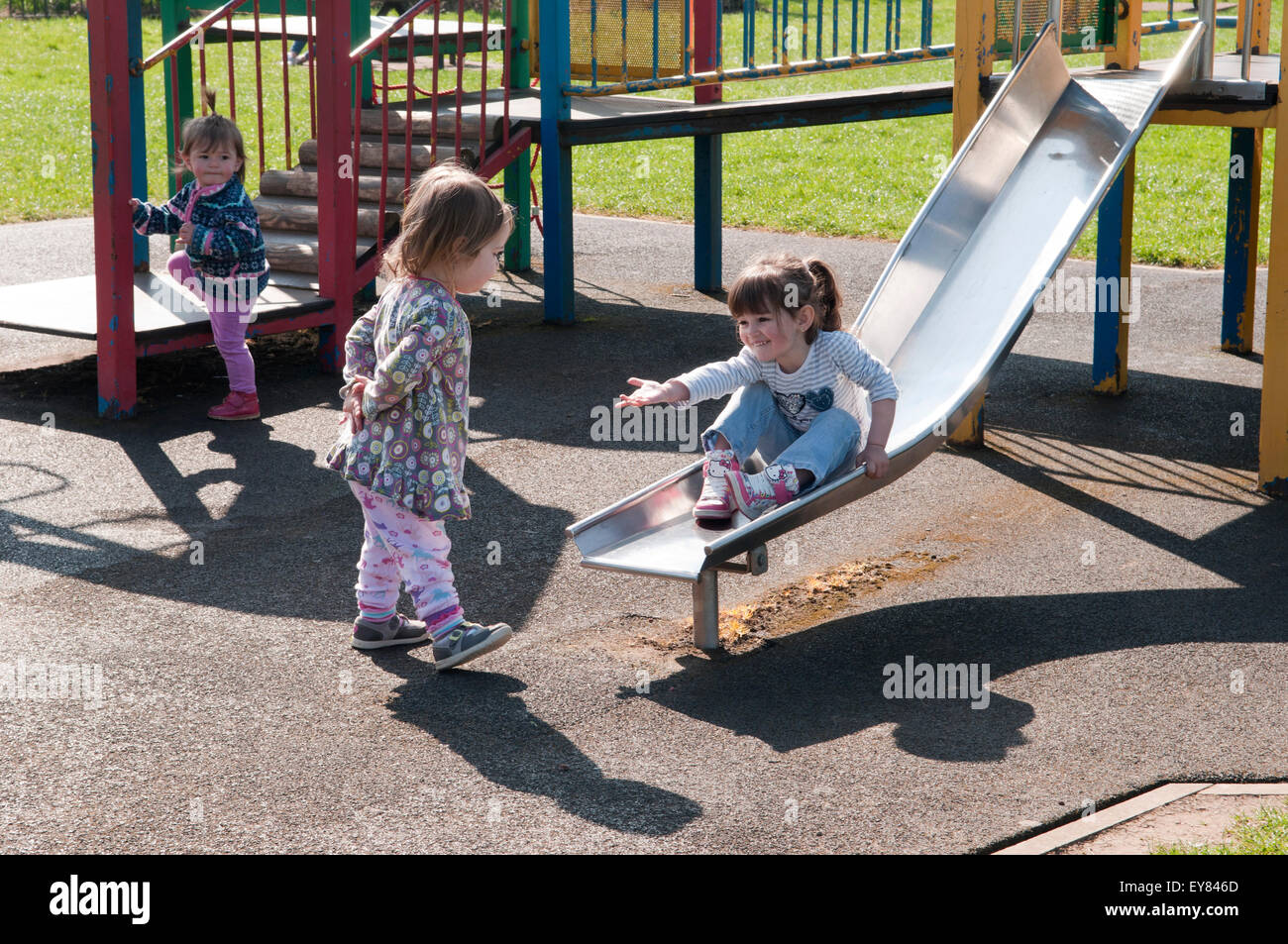 Three little girls playing together in the playground Stock Photo - Alamy