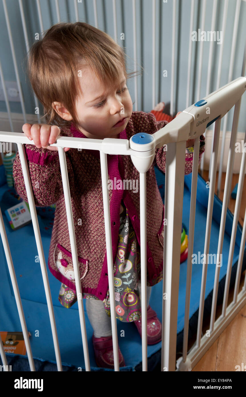Little girl standing in a playpen Stock Photo - Alamy