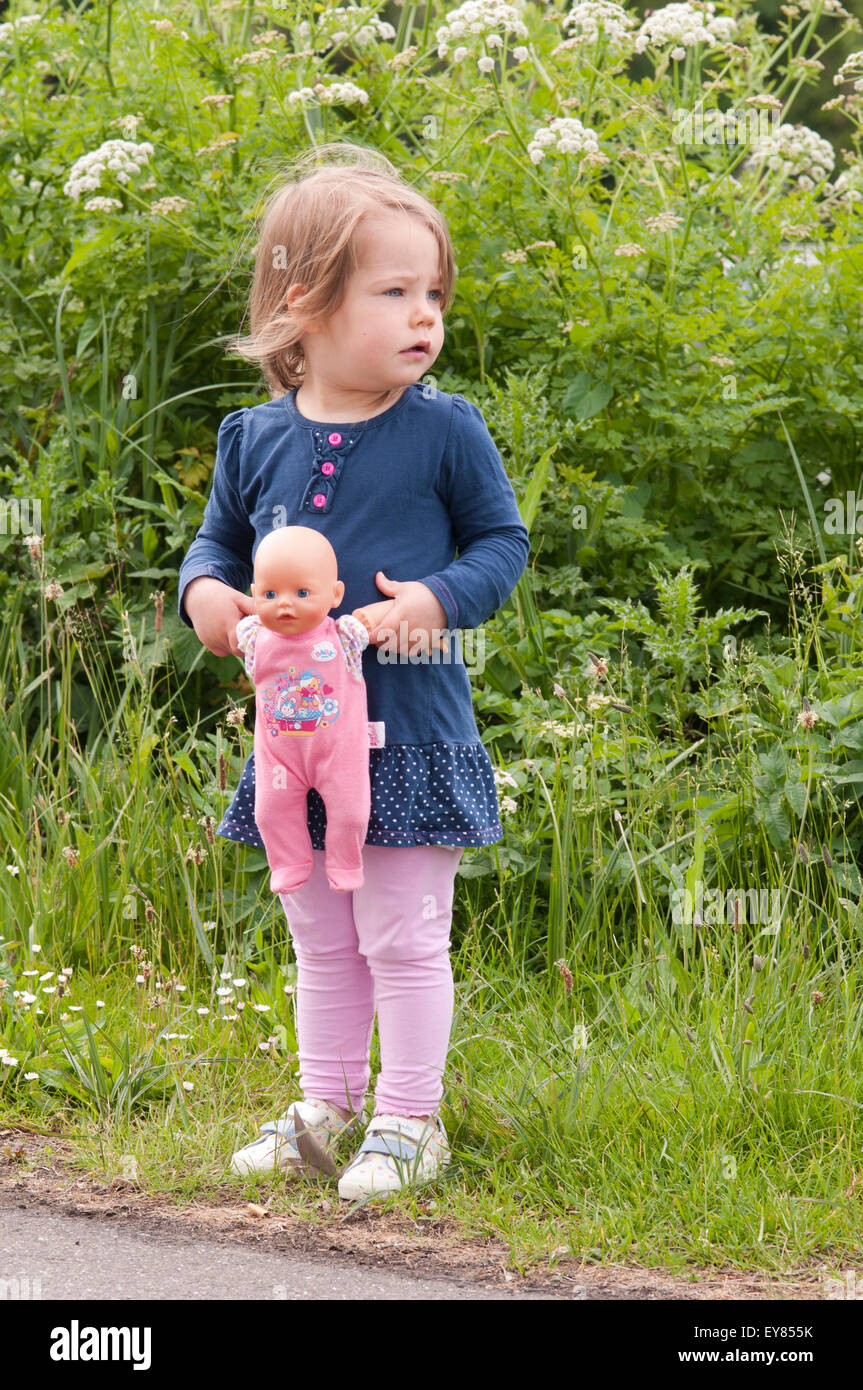 Little girl standing holding her doll Stock Photo - Alamy Little girl standing holding her doll Stock Photo - Alamy