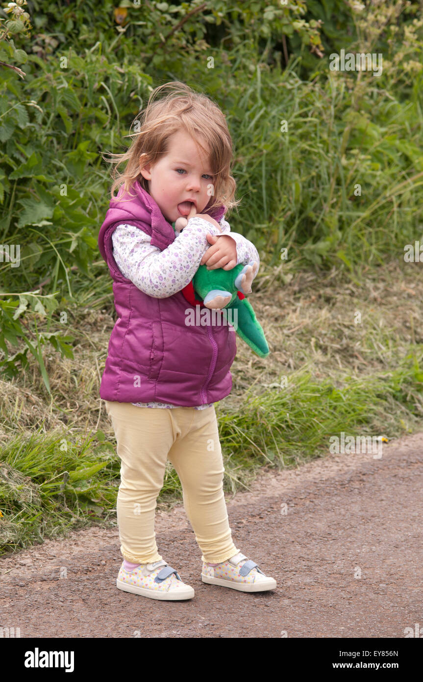 Little girl hugging a soft toy looking anxious Stock Photo - Alamy
