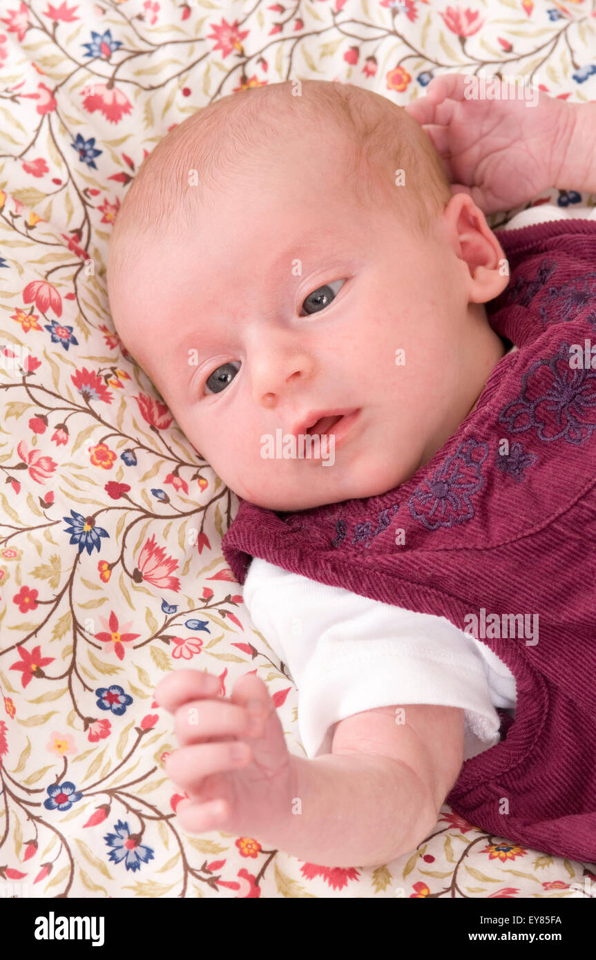 Portrait of newborn baby girl lying on bed awake Stock Photo - Alamy