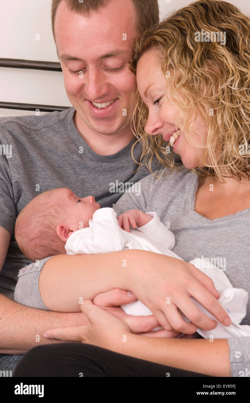 New parents holding, cuddling their newborn baby Stock Photo - Alamy