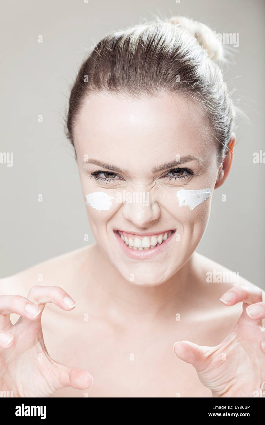 Young woman with streaks of lotion on face Stock Photo - Alamy