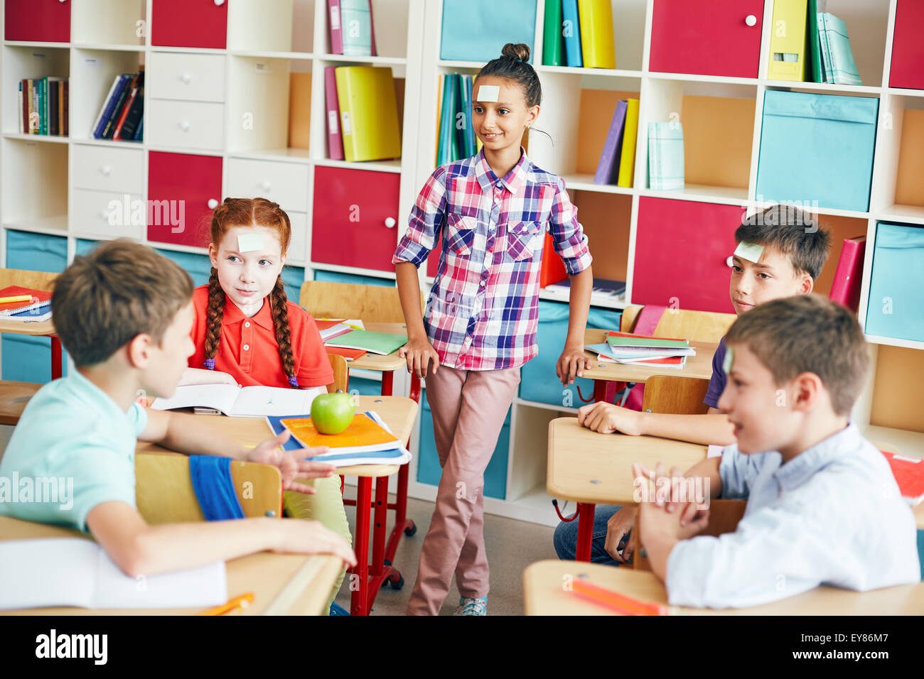 School friends playing ‘Who I am’ during break in classroom Stock Photo ...