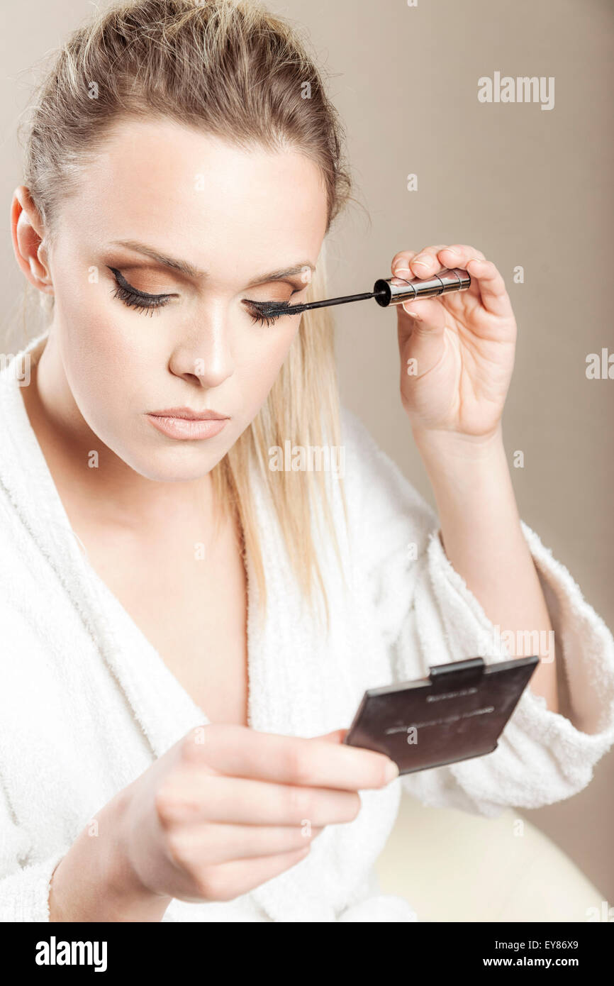 Young woman applying mascara Stock Photo - Alamy