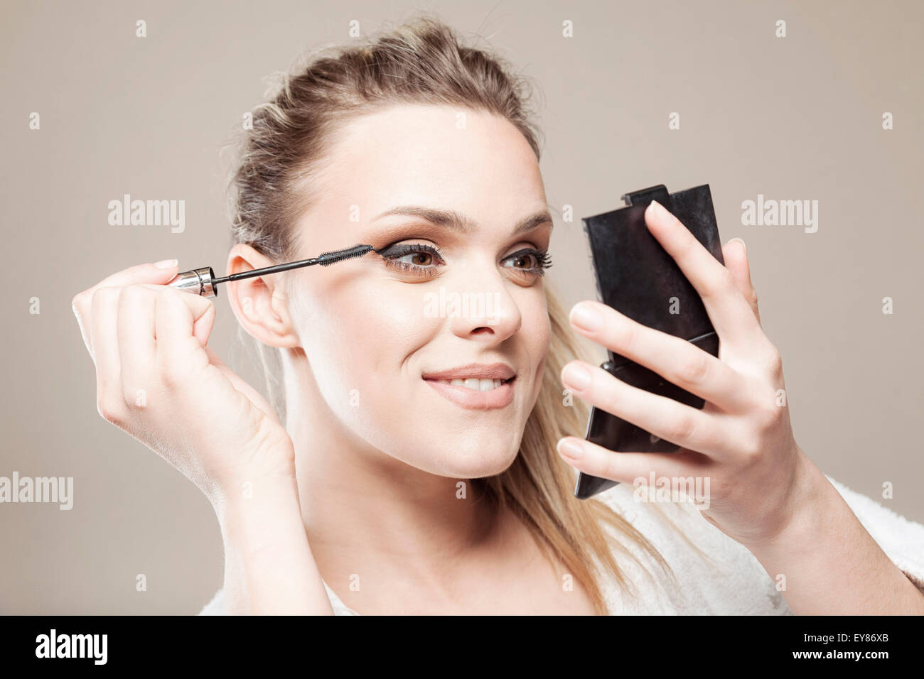 Young woman applying mascara Stock Photo - Alamy