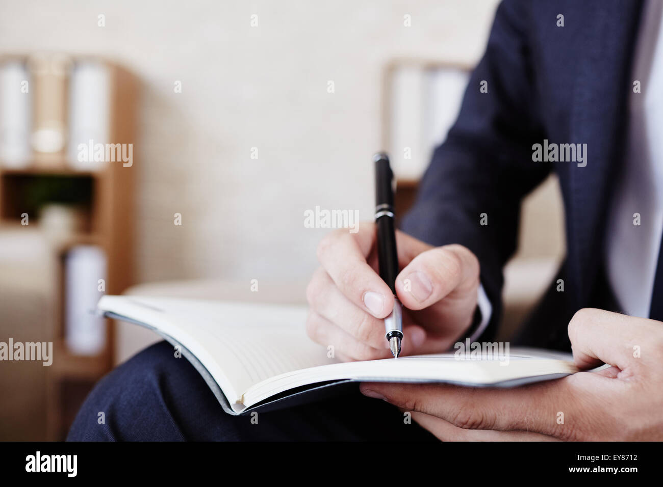 Male employee making notes in notepad Stock Photo - Alamy