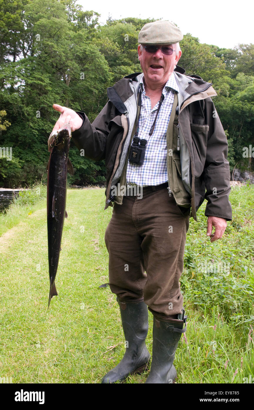 Happy angler holding a salmon Stock Photo - Alamy