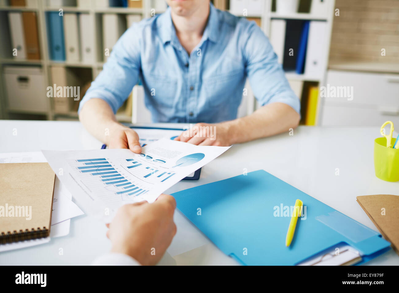 Male employee giving document with data to colleague Stock Photo - Alamy