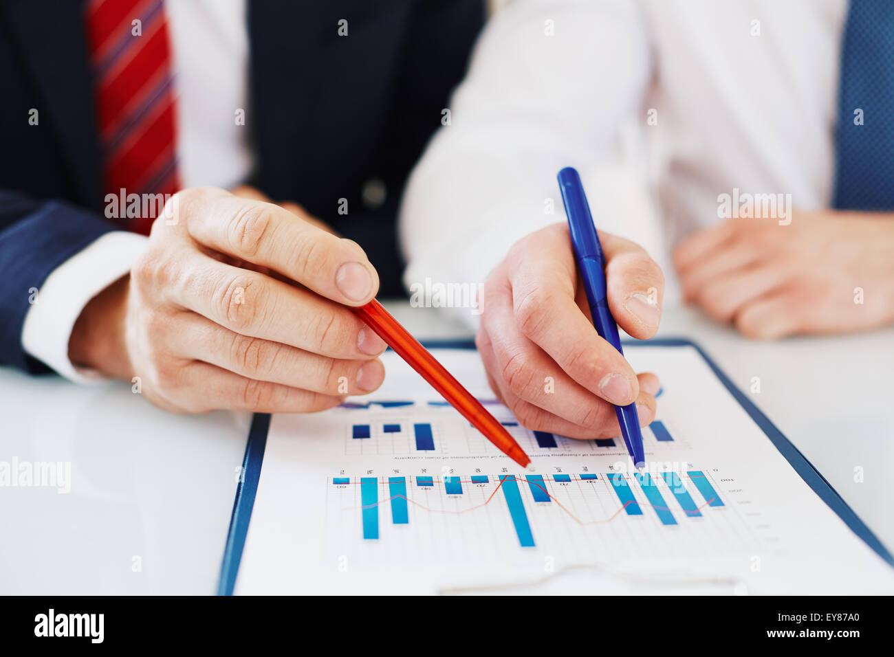 Two colleagues with pens pointing at document Stock Photo - Alamy