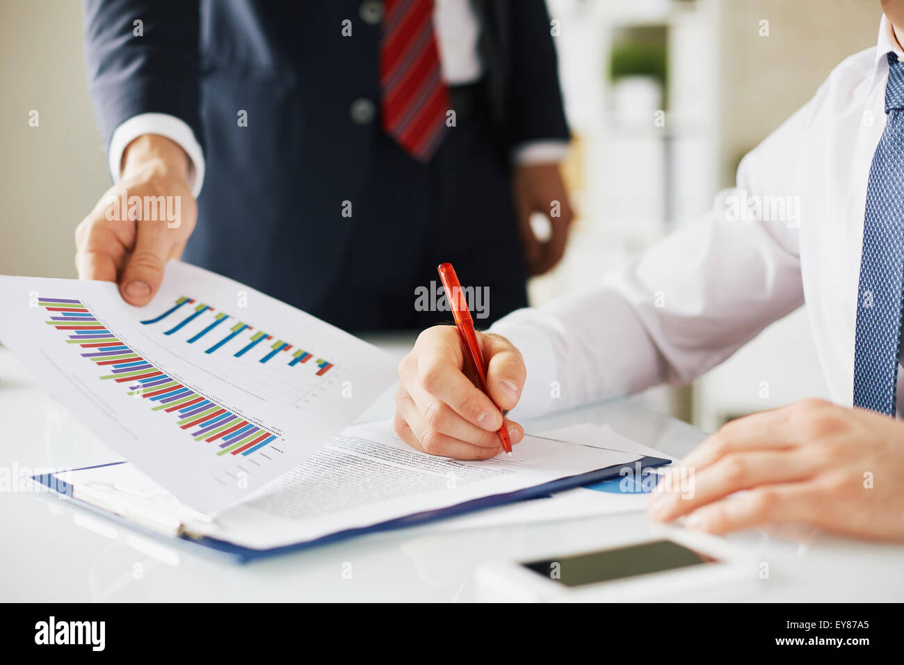 Employee giving document to boss while he signing contract Stock Photo ...