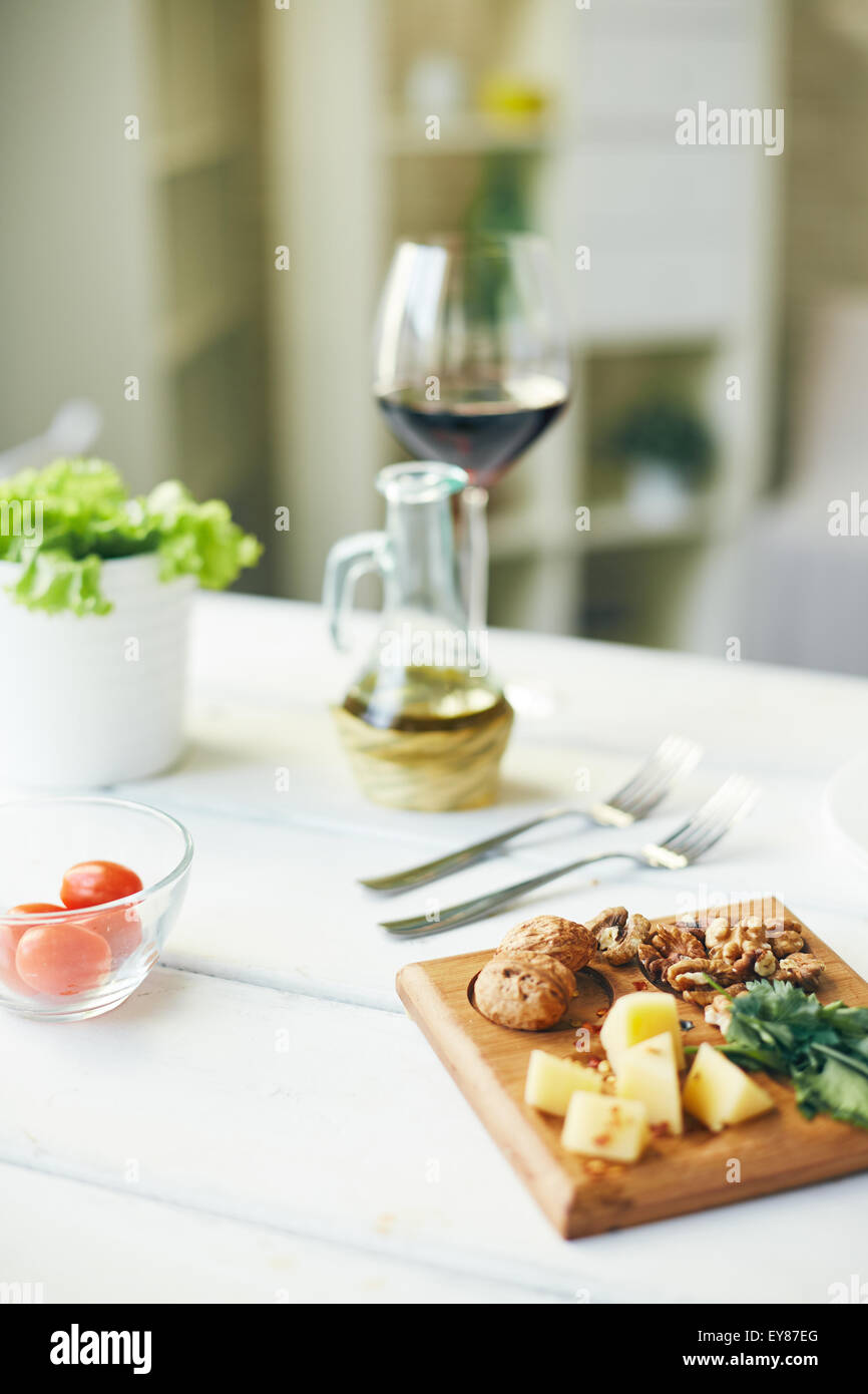Walnuts, cheese and green parsley on wooden utensil and other food on ...
