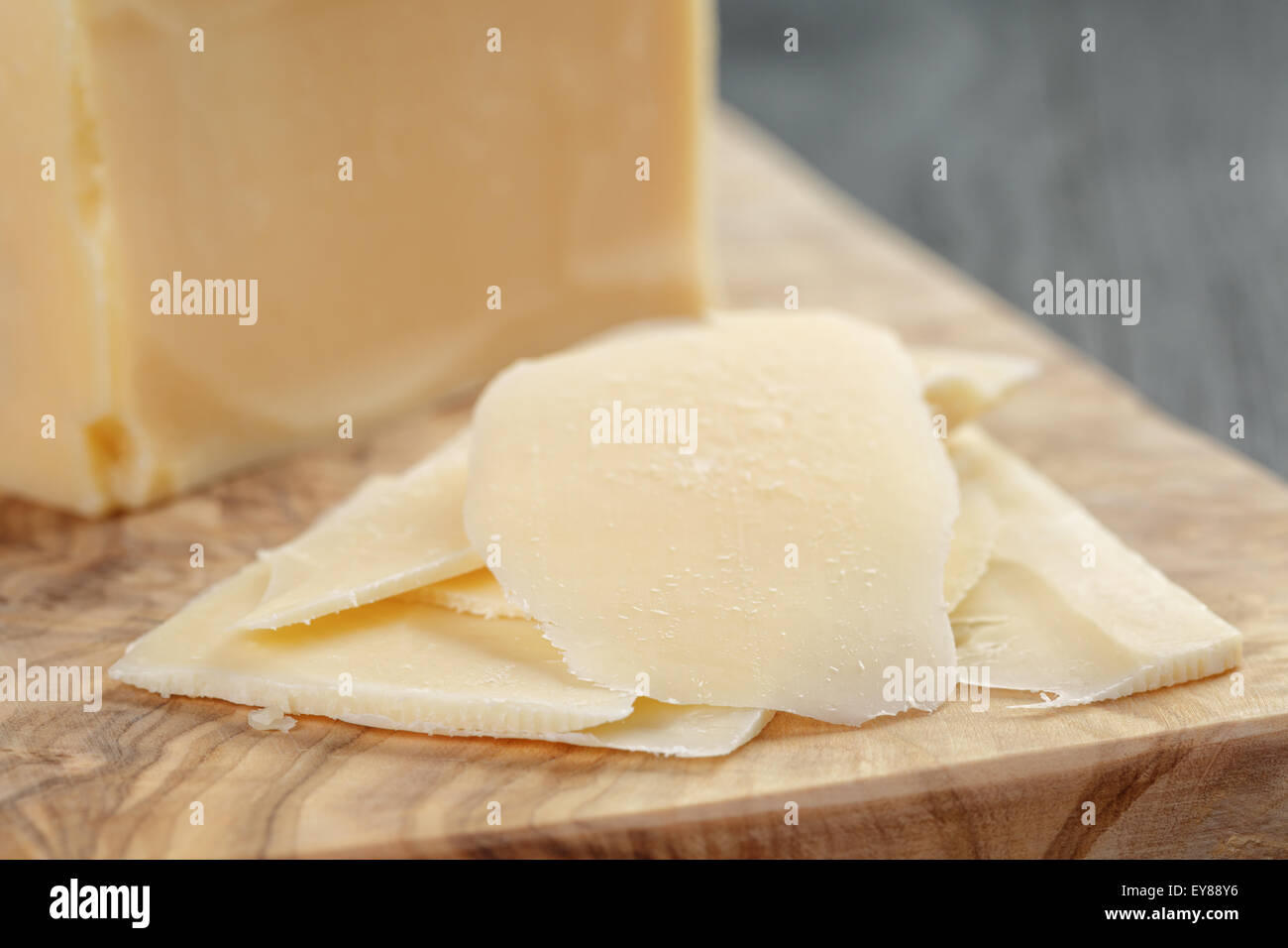 parmesan cheese sliced on olive board Stock Photo - Alamy